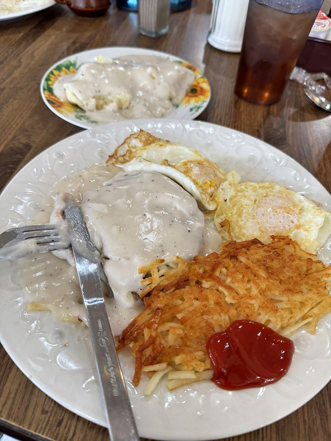 Biscuits and gravy that don't just cover the plate—they create a delicious landscape where your fork becomes an eager explorer.