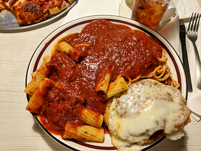 A plate that tells the whole story—pasta swimming in robust sauce alongside the star of the show: that magnificent chicken parmesan worth crossing county lines for.