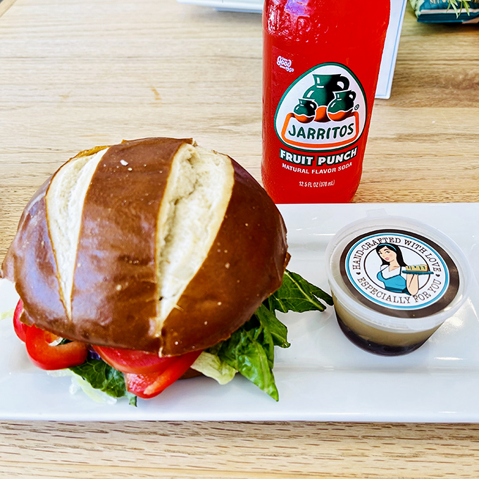 A pretzel bun sandwich that's dressed better than most people at the beach—notice how the greens add that perfect pop of color.