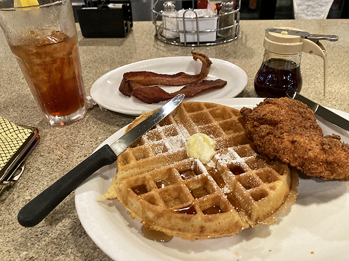 The breakfast power couple that never disappoints&mdash;golden waffles with a crispy fried chicken companion, plus bacon because why stop there?