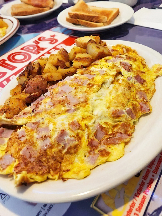 An omelette so stuffed with ham it's practically wearing a pork tuxedo. Those home fries on the side aren't just a garnish&mdash;they're essential supporting actors in this breakfast drama.