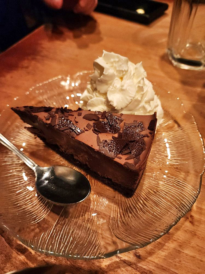 Chocolate mousse cake that's denser than a philosophical novel but infinitely more satisfying. The whipped cream is just showing off.