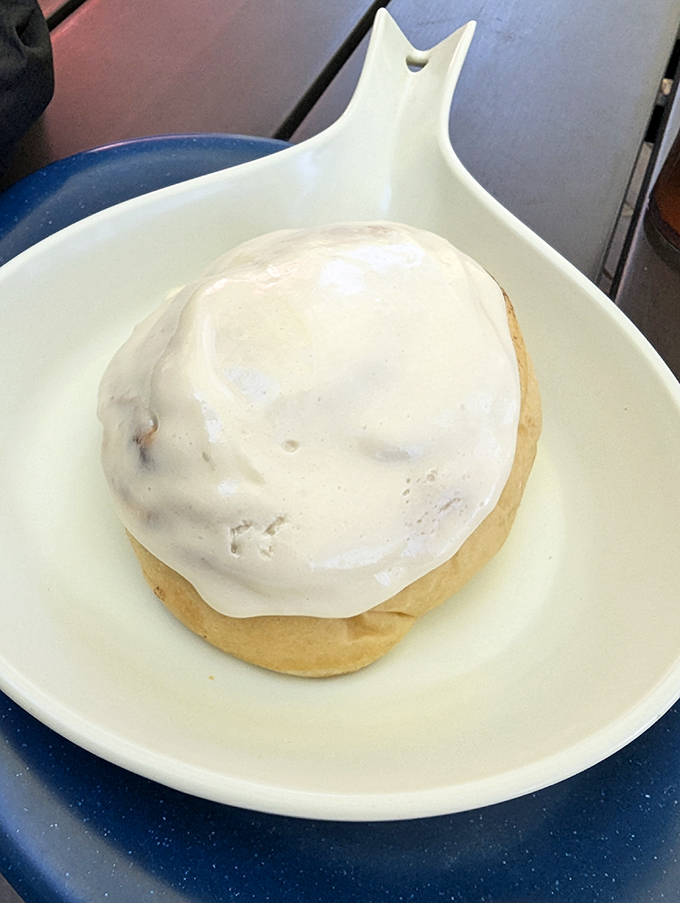 This isn't just a cinnamon roll&mdash;it's a pillowy spiral of morning bliss wearing a generous coat of cream cheese icing that melts into every nook.