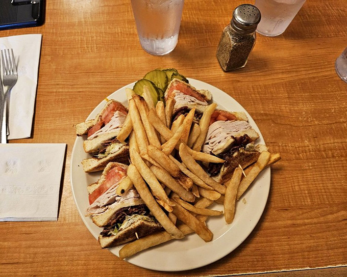 The club sandwich&mdash;architectural marvel of the diner world, where each layer tells its own delicious story.