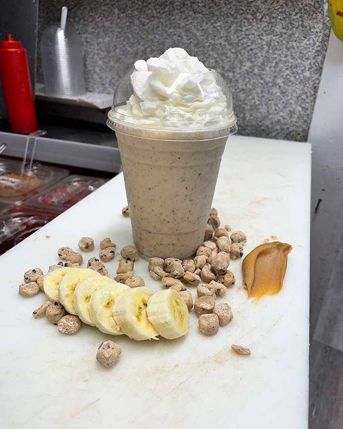 The menu board: where dreams are displayed in neat rows and diet plans go to die. Each handwritten flavor name tells a story of culinary creativity.