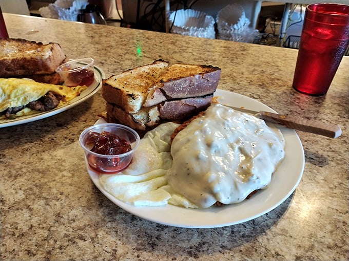 Country fried steak swimming in creamy gravy alongside buttery toast &ndash; comfort food that hugs your soul while simultaneously plotting against your arteries.