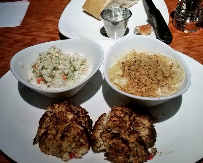 These crab cakes and their accompanying sides look like they're posing for a family portrait. Minimal filler, maximum flavor – the way the seafood gods intended.