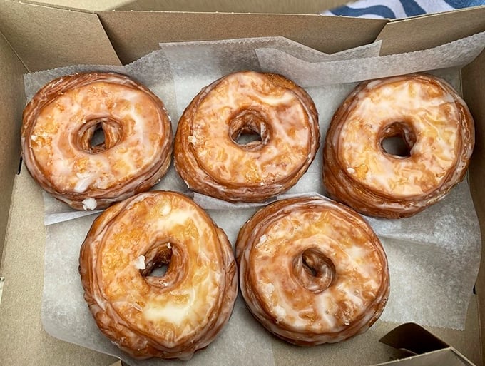Five glazed cronuts in formation, ready to deploy their mission of bringing morning bliss to whoever claims this cardboard carrier.