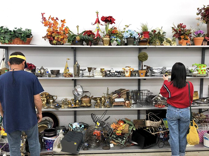 Two treasure hunters contemplating brass and artificial foliage. In the thrift store universe, someone's "what was I thinking?" becomes another's "exactly what I needed!"