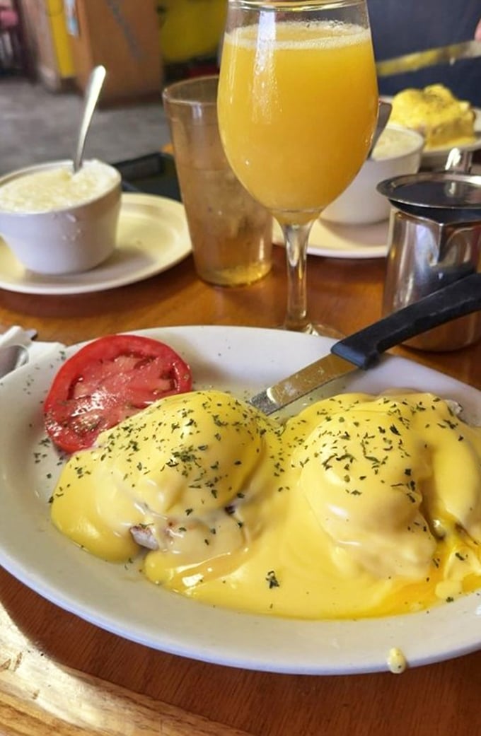 Eggs Benedict with a Florida twist &ndash; sunshine-yellow hollandaise cascading over poached eggs like a breakfast waterfall, with a splash of orange juice to complete the morning.