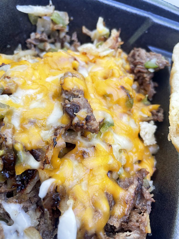 Melted cheese cascades over seasoned steak and peppers in this plate that says "Yes, potatoes CAN be the main event."