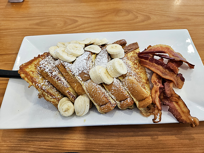 The legendary French toast that launched a thousand road trips, dusted with powdered sugar and served with perfectly crisp bacon.