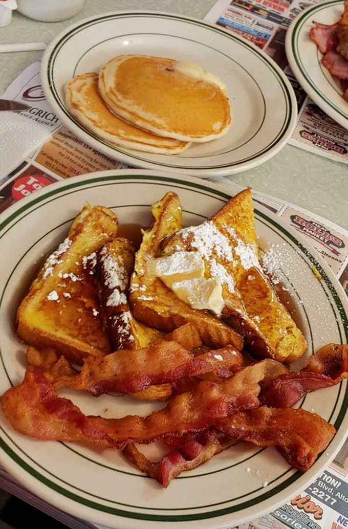 French toast dusted with powdered sugar, crispy bacon, and golden pancakes—the breakfast trinity that makes getting out of bed worthwhile.