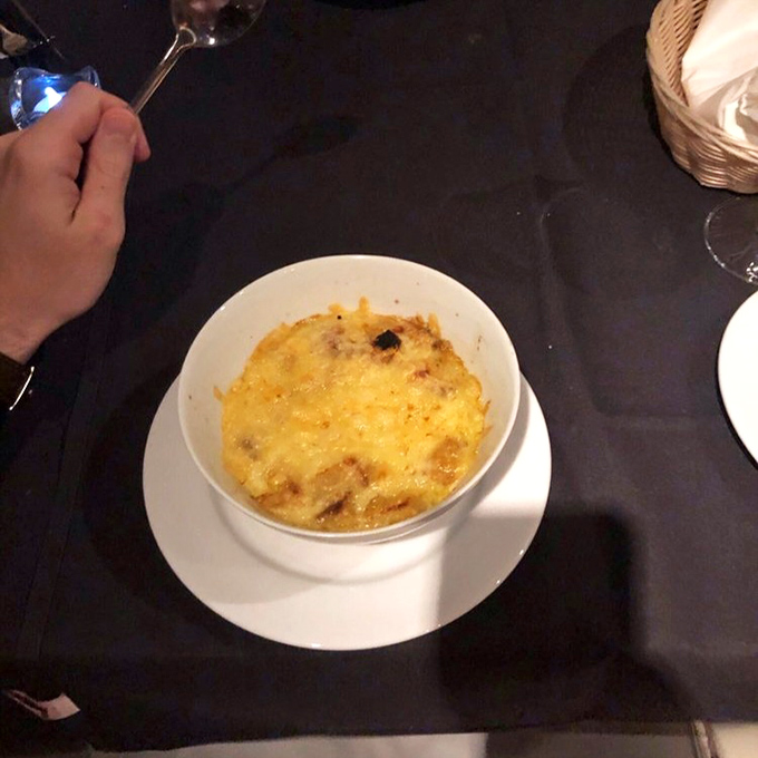 French onion soup that's having an identity crisis as liquid gold. That melted cheese cap is stretching toward immortality in the comfort food hall of fame.