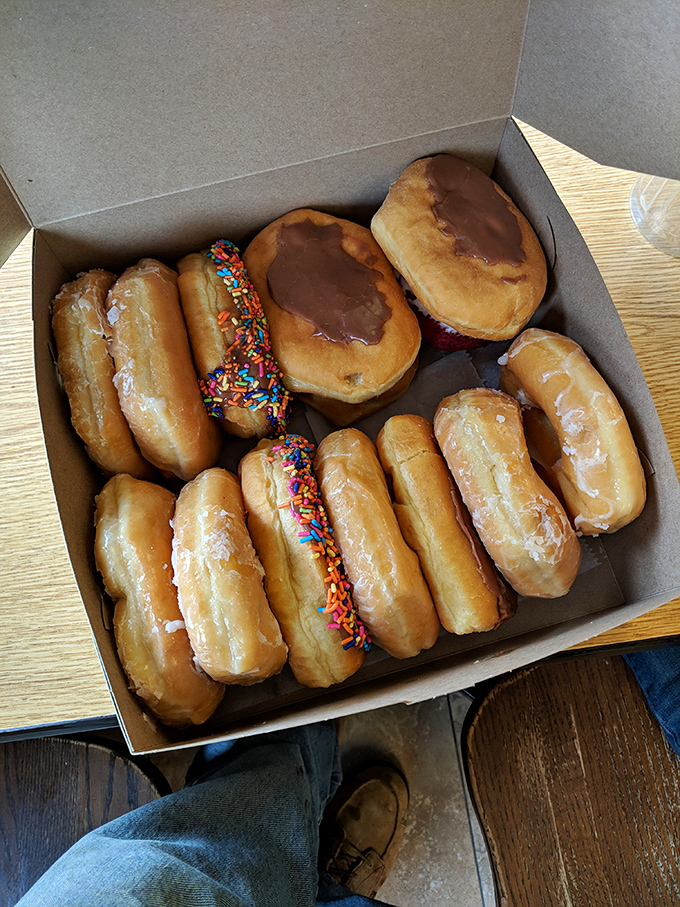A dozen reasons to break your diet, neatly arranged in a simple cardboard box. The sprinkled ones are practically winking at you.