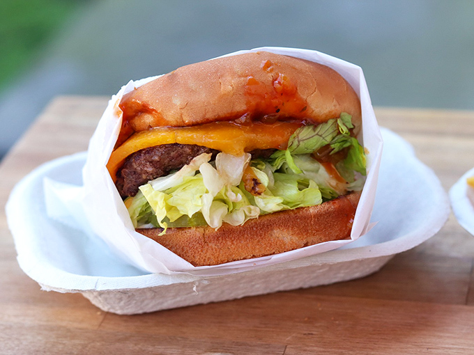 The Hickoryburger arrives wrapped like a gift, its smoky sauce and fresh toppings creating a flavor symphony that makes you wonder why anyone bothered inventing truffle aioli in the first place.