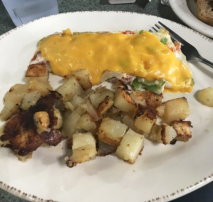 An omelet wearing a golden cheese cape, accompanied by home fries that achieved the perfect crisp-to-tender ratio. Breakfast of champions, indeed.