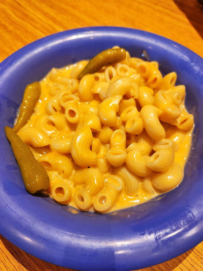 Mac and cheese that doesn't just sit on the plate but demands attention with its vibrant color and creamy texture. Comfort in a blue bowl.