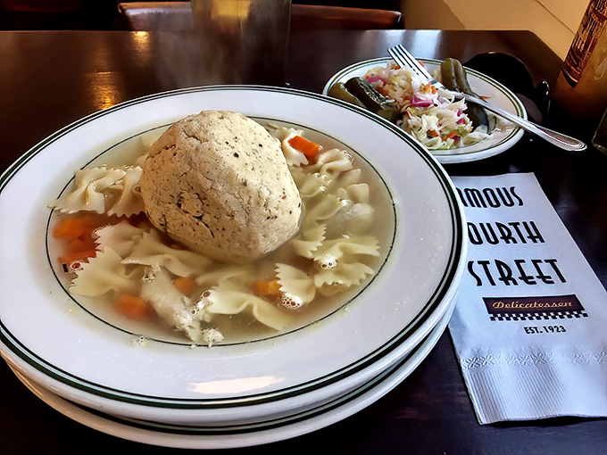 That matzo ball isn't floating&mdash;it's holding court in a golden broth that tastes like your grandmother's kitchen, assuming your grandmother was a culinary genius.