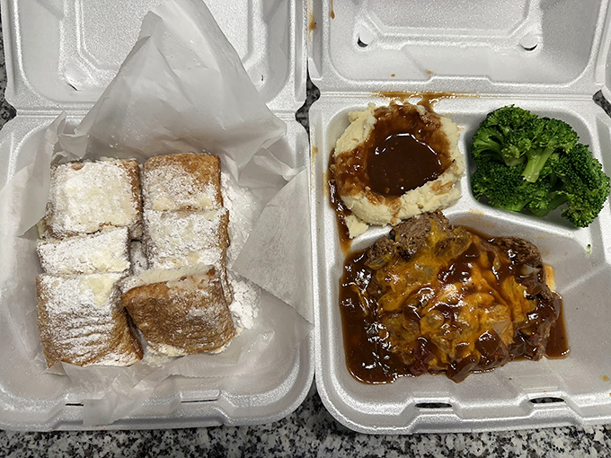 Even in takeout form, the meatloaf maintains its dignity, nestled beside powdered beignets that whisper sweet nothings to your taste buds.