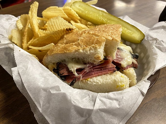 A basket of happiness featuring a sandwich, chips, and pickle. The holy trinity of lunch, presented with the reverence it deserves.