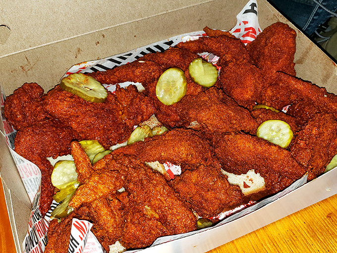 These crimson-coated pieces nestled among pickles aren't just chicken—they're an endorphin delivery system disguised as lunch.