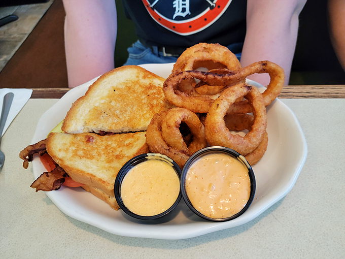 A sandwich that knows its supporting cast matters. Those golden onion rings deserve their own standing ovation and dipping sauce encore.