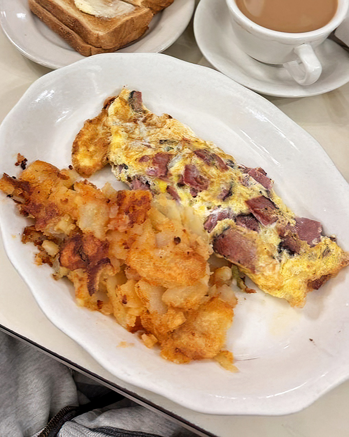 When breakfast meets artistry: a ham-packed omelet alongside home fries that achieve that elusive crispy-yet-tender texture. Morning glory on a plate.