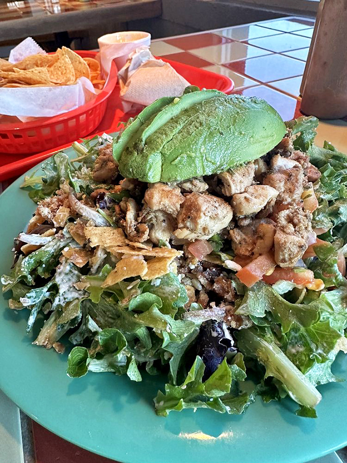 A salad that doesn't apologize for being delicious, crowned with a perfect avocado half like nature's butter trophy.