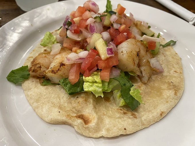 Fresh ingredients tell a story on this handmade tortilla—crisp lettuce, diced tomatoes, and succulent shrimp create a handheld fiesta.