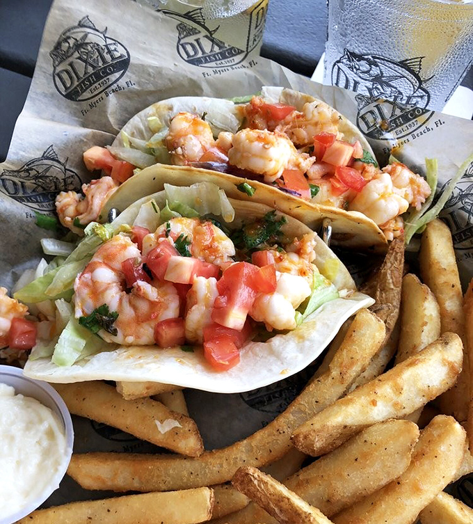 Taco Tuesday found its forever home. Plump shrimp nestled in soft tortillas with fresh tomatoes and crisp lettuce, served with fries that demand dunking.
