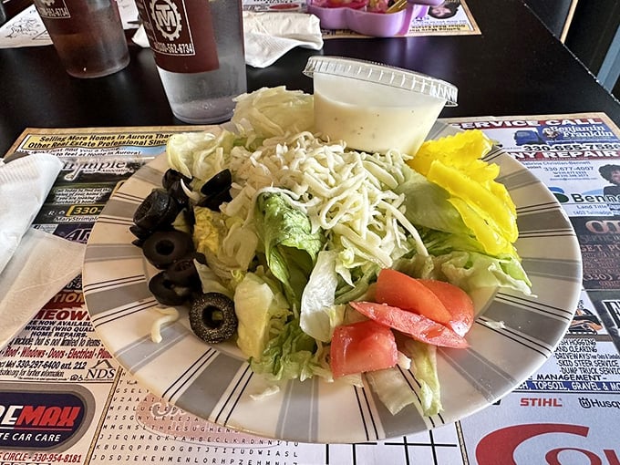 Even the side salad gets the full treatment, with olives, tomatoes, and shredded cheese transforming this obligatory healthy option into something you'll actually finish.