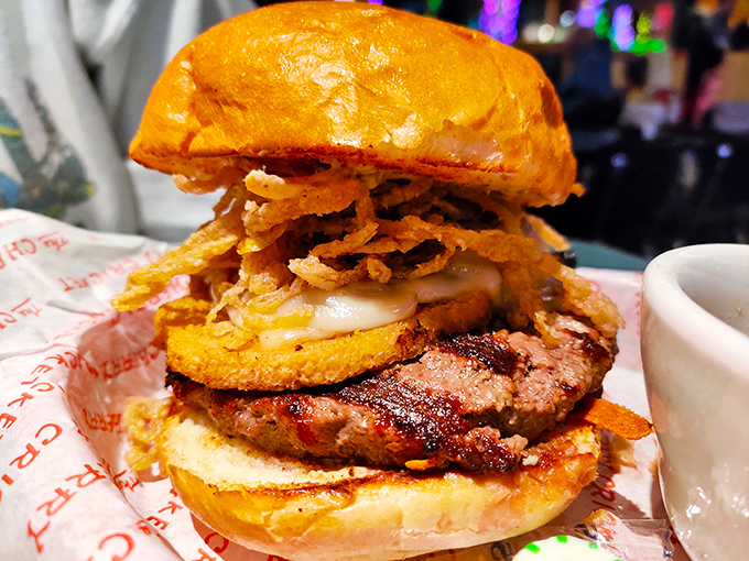 A burger that defies gravity and good manners. Some sandwiches you eat; this one you conquer, with melty cheese and crispy onions as your reward.