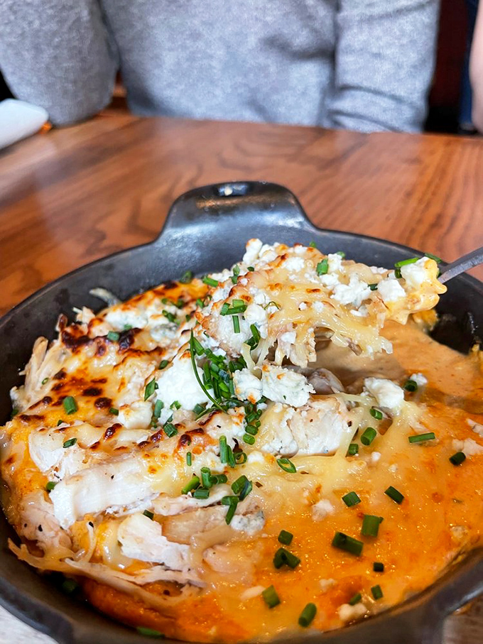 The spicy chicken dip delivers all the buffalo chicken wing flavor without the awkward bone-negotiating gymnastics. Genius in a skillet.