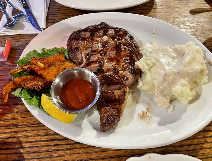 When land meets sea on a plate. This T-bone with its perfectly crosshatched grill marks plays nicely with those golden-fried shrimp and cloud-like mashed potatoes.