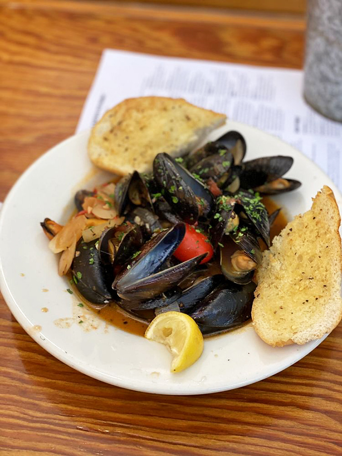 These mussels aren't just steamed, they're transformed into little black-shelled vessels of brothy perfection. The garlic bread isn't optional.