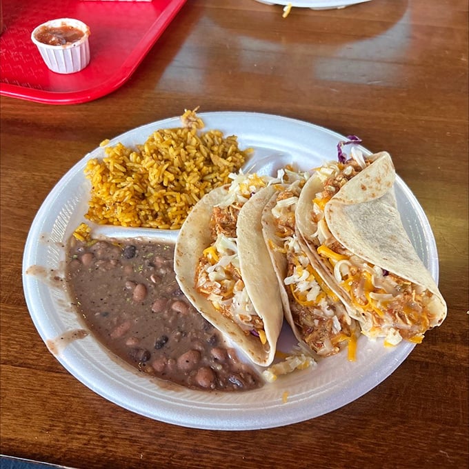 A taco platter that hits all the right notes – perfectly seasoned rice, soulful beans, and tacos stuffed with enough filling to require a two-hand grip.
