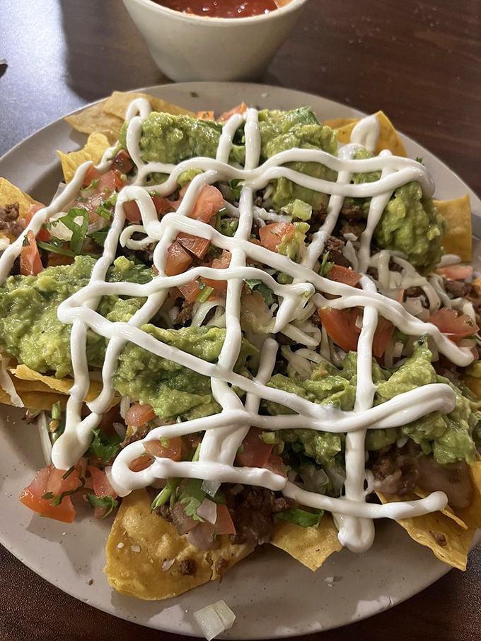 Loaded nachos that refuse to cut corners. That lattice of sour cream isn't just for show&mdash;it's the finishing touch on a mountain of flavor.