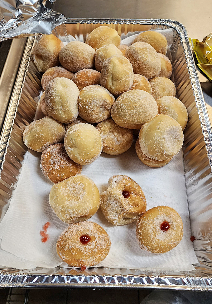 These aren't just donuts; they're pillowy spheres of joy dusted with sugar and filled with fruit that would make your grandmother weep with pride.