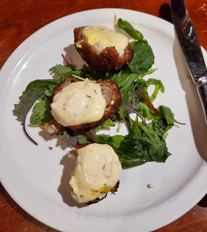 These aren't your average meatballs &ndash; they're dressed for a royal occasion, perched atop greens and crowned with a sauce that demands to be savored.