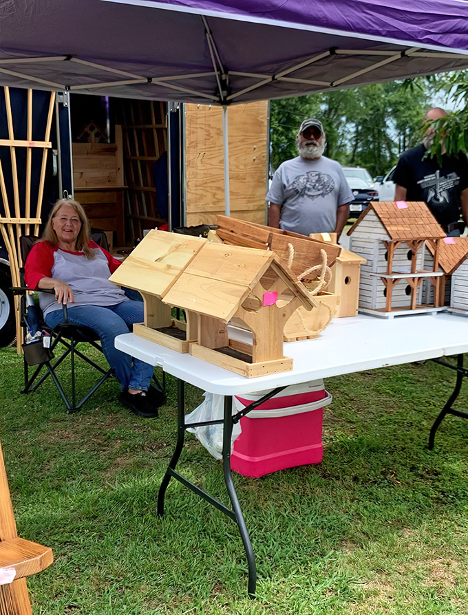 Craftsmanship on display. Handmade birdhouses await new homes while their creators share the satisfaction of working with wood and simple tools.