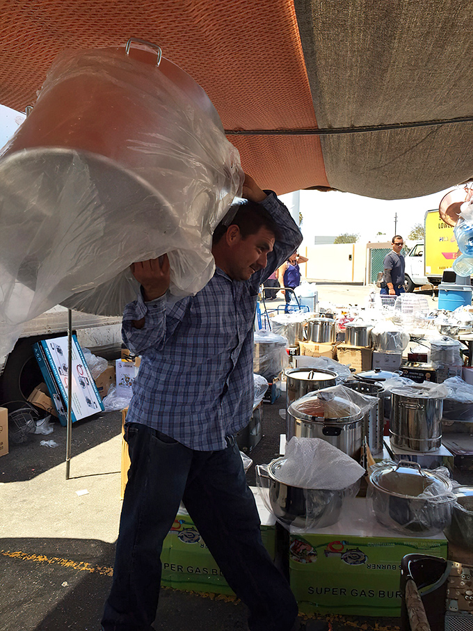 The unsung hero of the swap meet: a vendor carefully transporting kitchenware that will soon become the heart of someone's home cooking adventures.