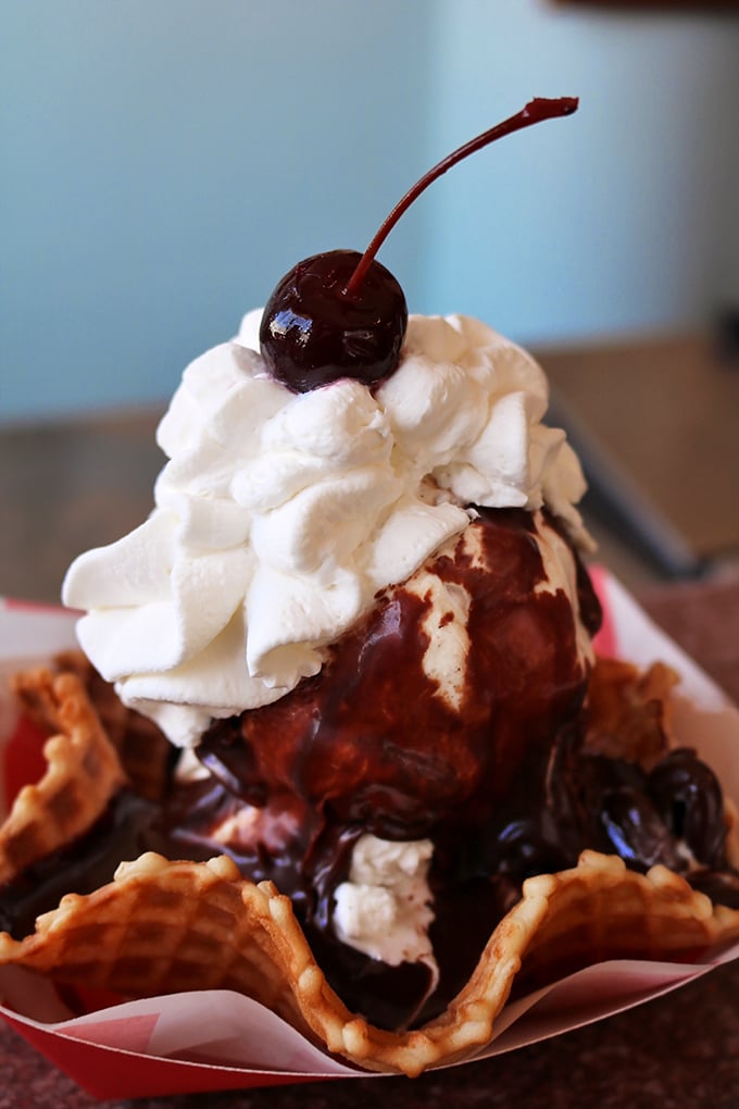 Ice cream nestled in a waffle cone, crowned with hot fudge and a cherry&mdash;proof that sometimes the universe does, in fact, love us back.