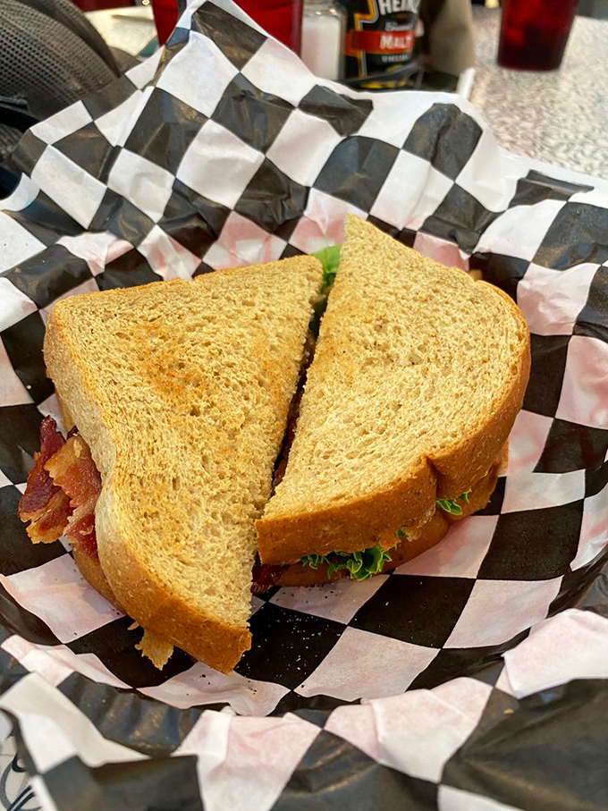 The humble BLT, elevated to art form. Between those golden slices lies the perfect ratio of bacon, lettuce, and tomato—a sandwich that understands balance.