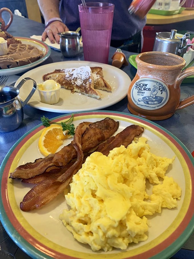The breakfast trinity: perfectly scrambled eggs, bacon cooked to that magical crisp-yet-tender state, and French toast dusted with powdered sugar dreams.