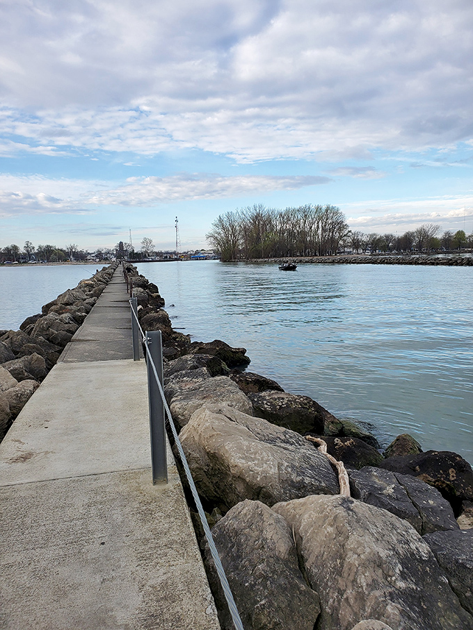 The breakwater stretches like a concrete runway into Lake Erie's blue expanse, inviting adventurous souls to walk the line between land and water.