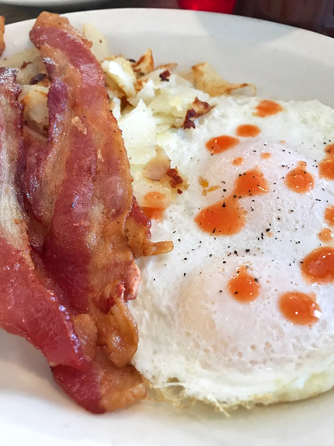 The breakfast purist's delight&mdash;perfectly cooked eggs with that vibrant sunset yolk, crispy bacon, and hash browns crisped to precise perfection.