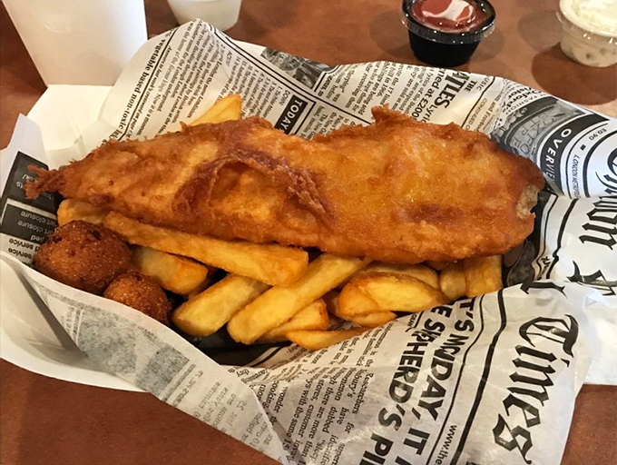 The fish sandwich arrives like royalty on a throne of newspaper, golden-battered and ready for its moment in the Florida sun.