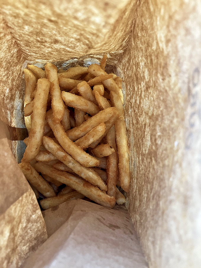 French fries hiding in their paper bag like gold in Fort Knox &ndash; crispy, golden, and worth every calorie-counting exception you'll make.