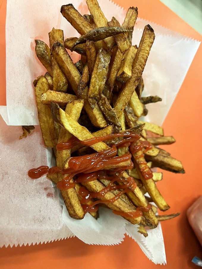 Hand-cut fries with ketchup applied with the precision of Jackson Pollock. Crispy outside, fluffy inside&mdash;the way the potato gods intended.
